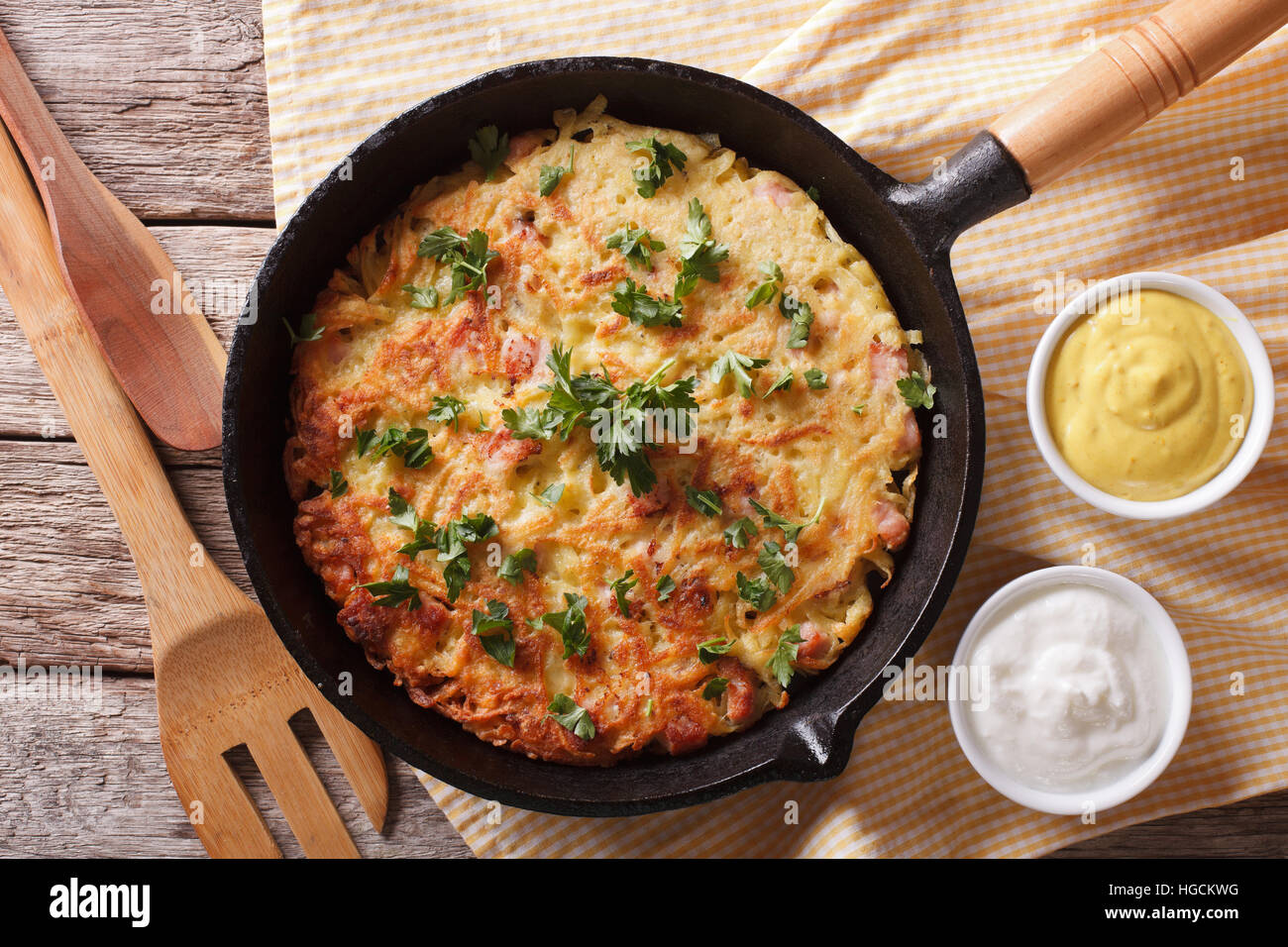 Swiss rosti with herbs close-up in a frying pan on the table ...