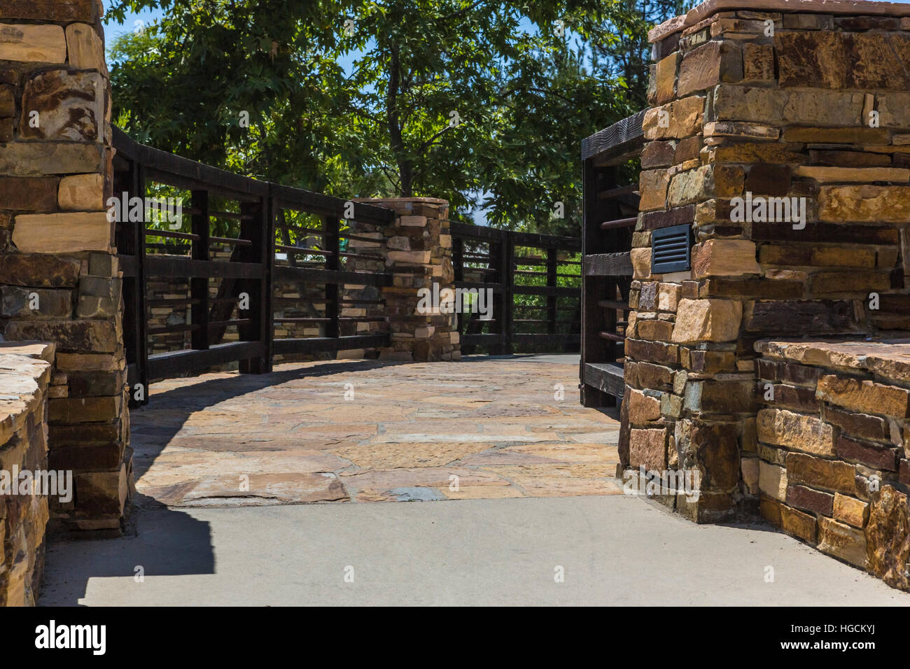 colorful stone bridge with railing over stream in park Stock Photo - Alamy