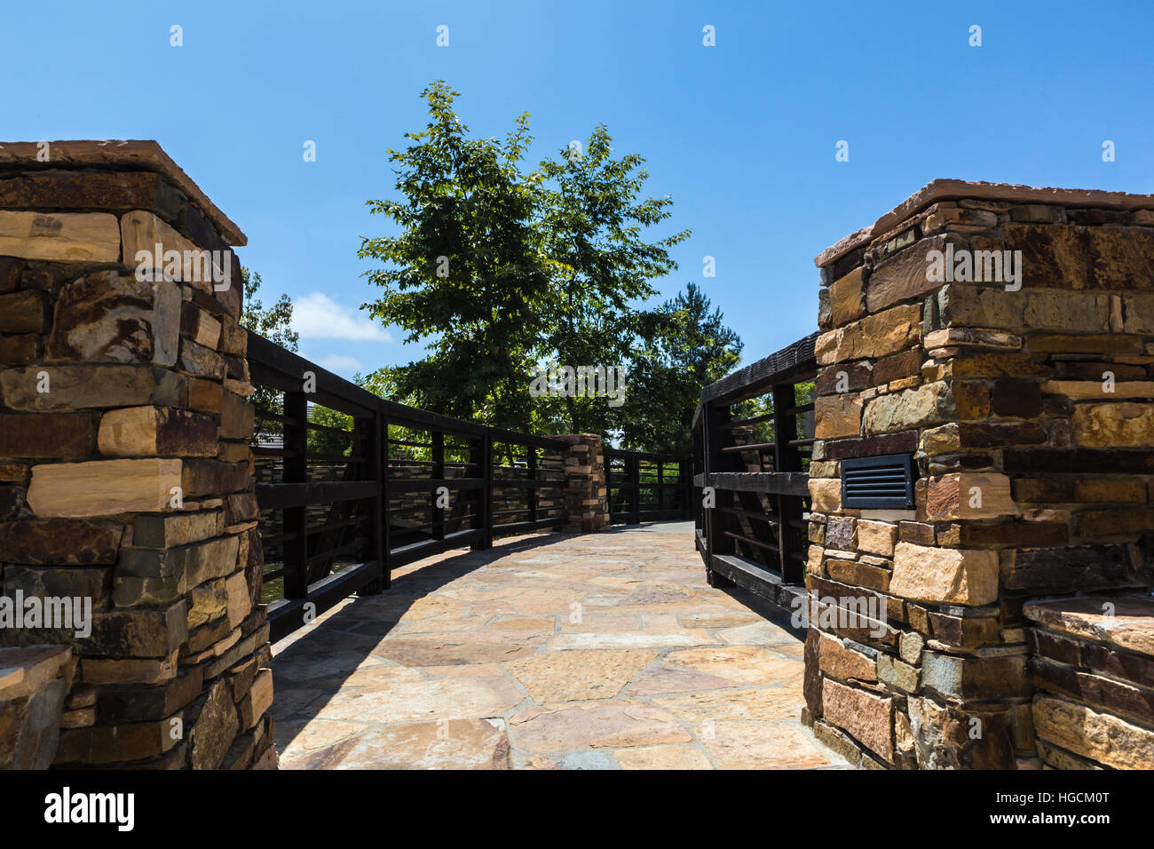 colorful stone bridge with railing over stream in park Stock Photo - Alamy