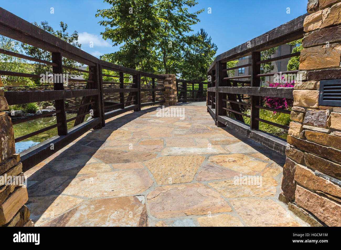 colorful stone bridge with railing over stream in park Stock Photo - Alamy