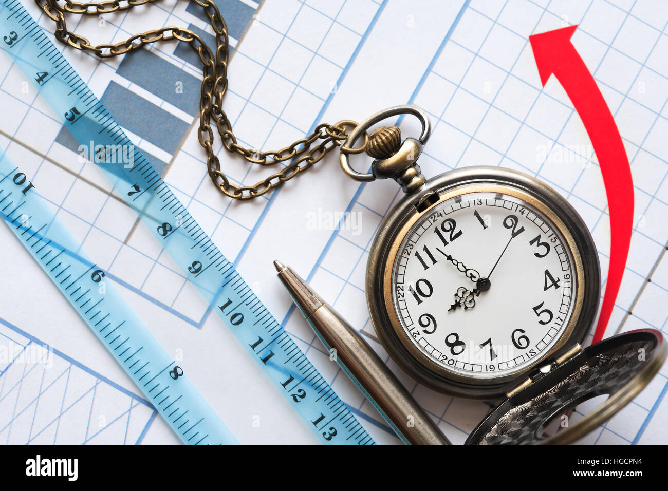 Business concept. Watch and ruler on paper background with red chart ...