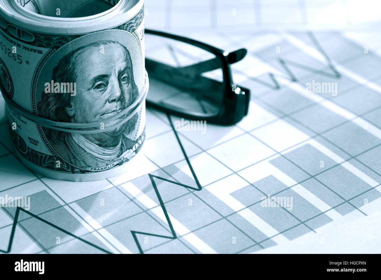 Business concept. Roll of money near spectacles on paper background ...