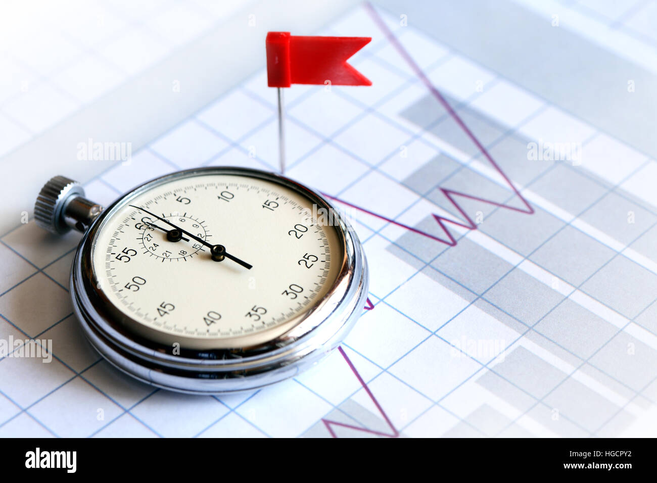 Business concept. Red flag thumbtack near stopwatch on paper background ...