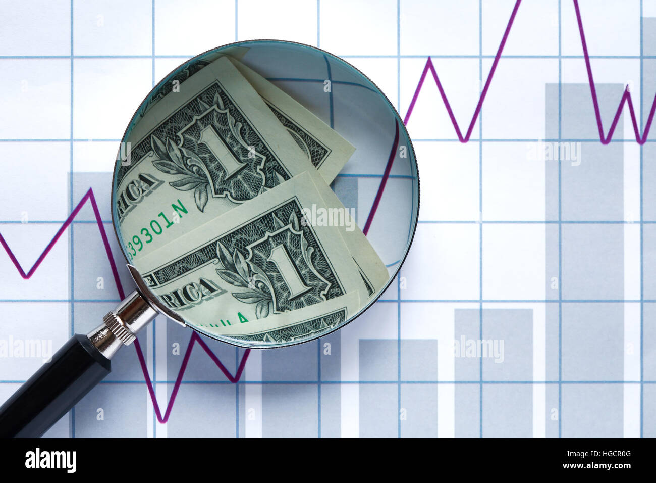 One dollar bank notes inside magnifying glass on paper background with ...