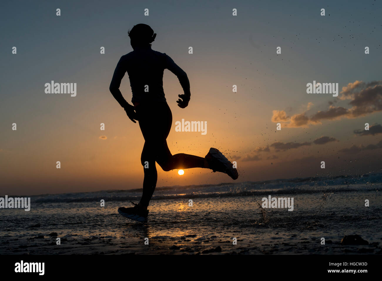 Runner on the beach for sunset Stock Photo - Alamy