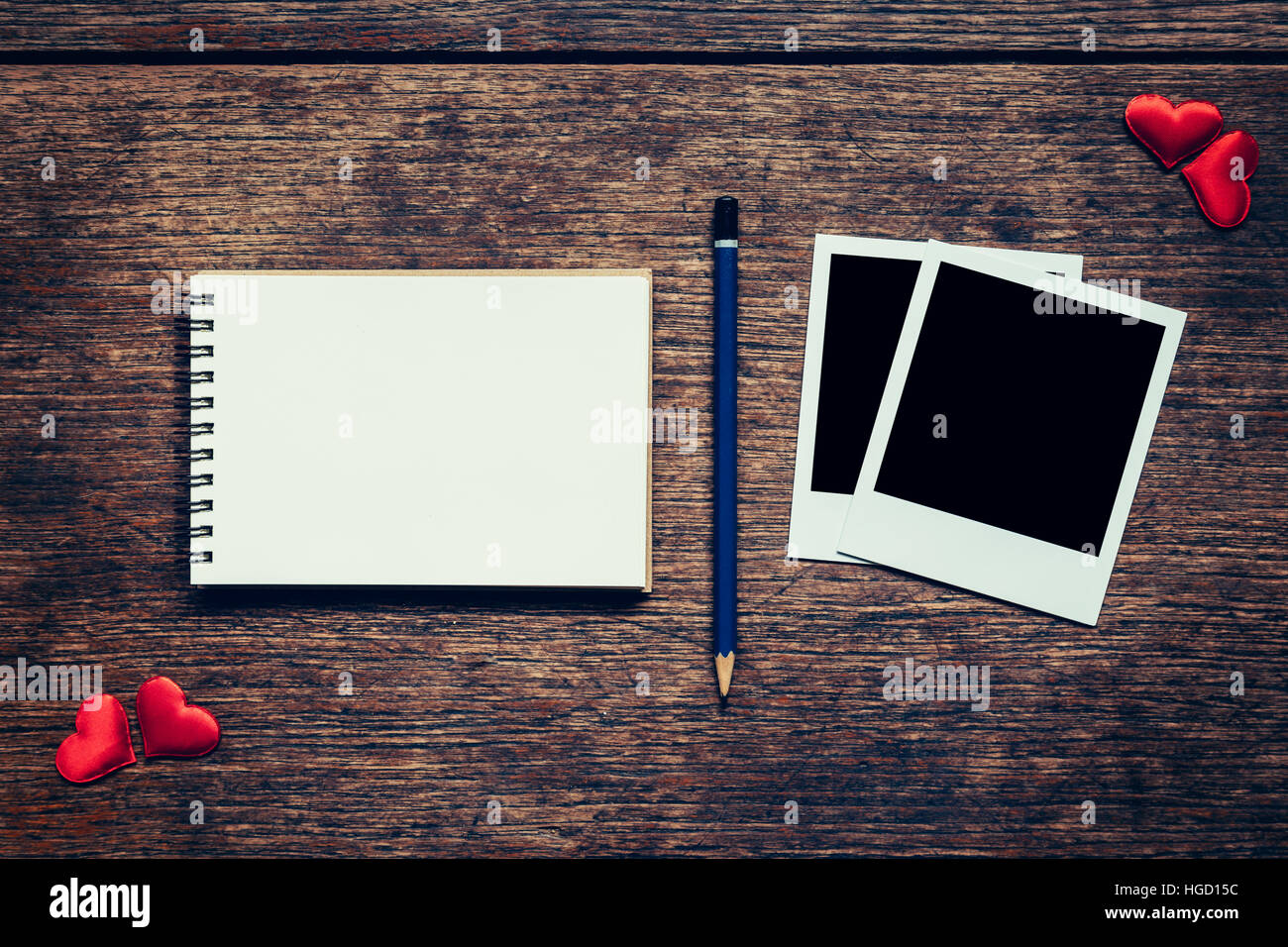 Blank photo frame, notebook, pencil and red heart on wood table ...