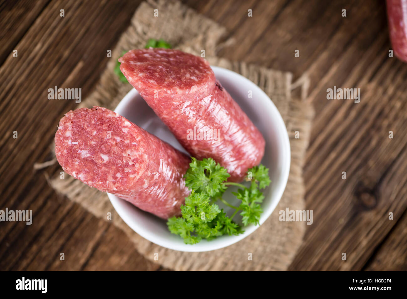 German Mettwurst (selective focus; detailed close-up shot) on wooden ...