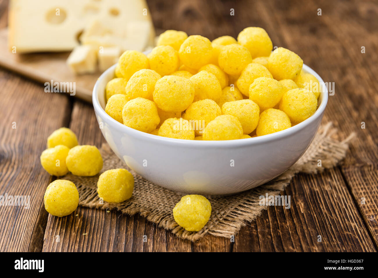 Cheese Balls (fried) as high detailed close-up shot on a vintage wooden ...