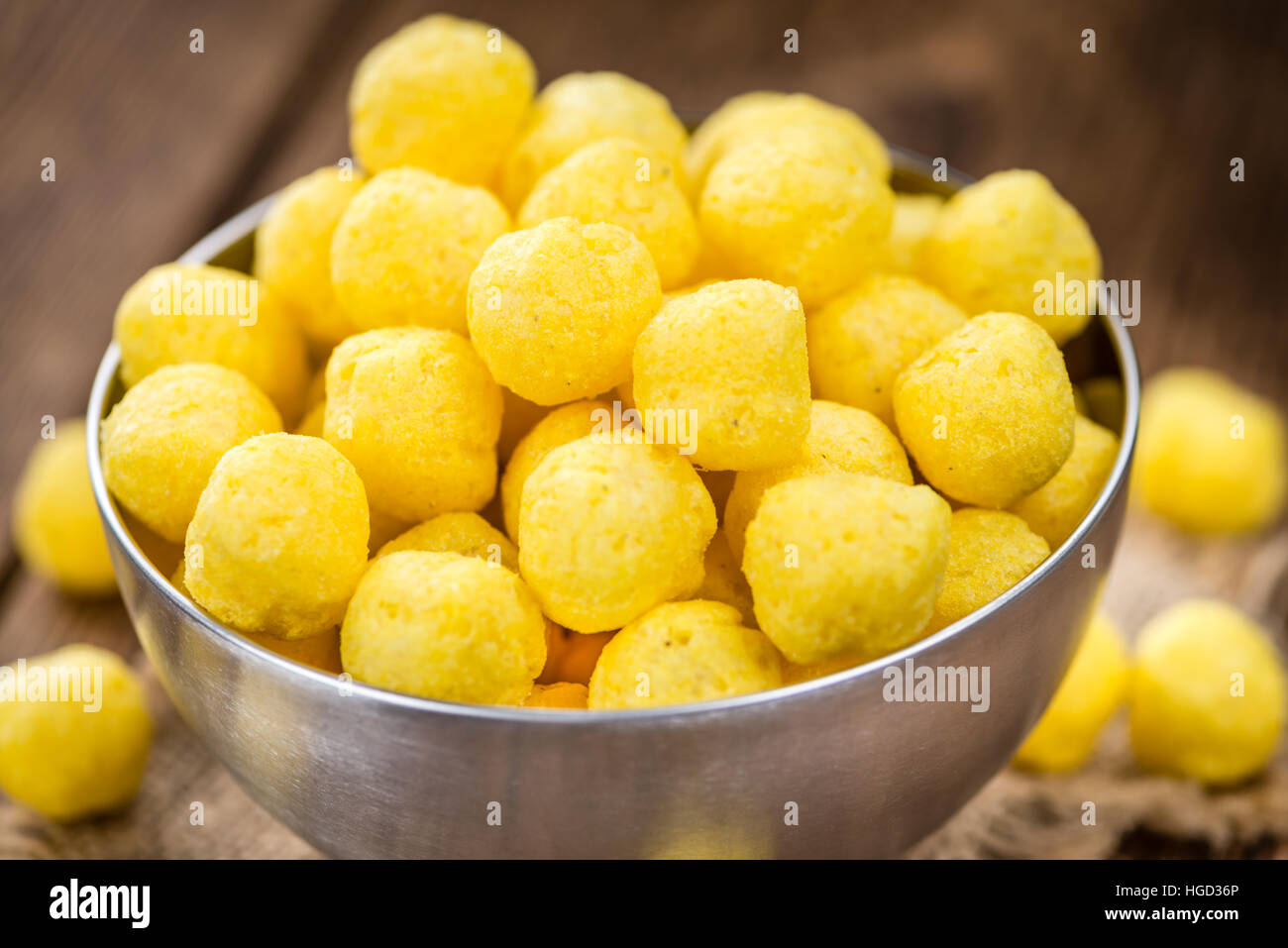 Cheese Balls (fried) as high detailed close-up shot on a vintage wooden ...