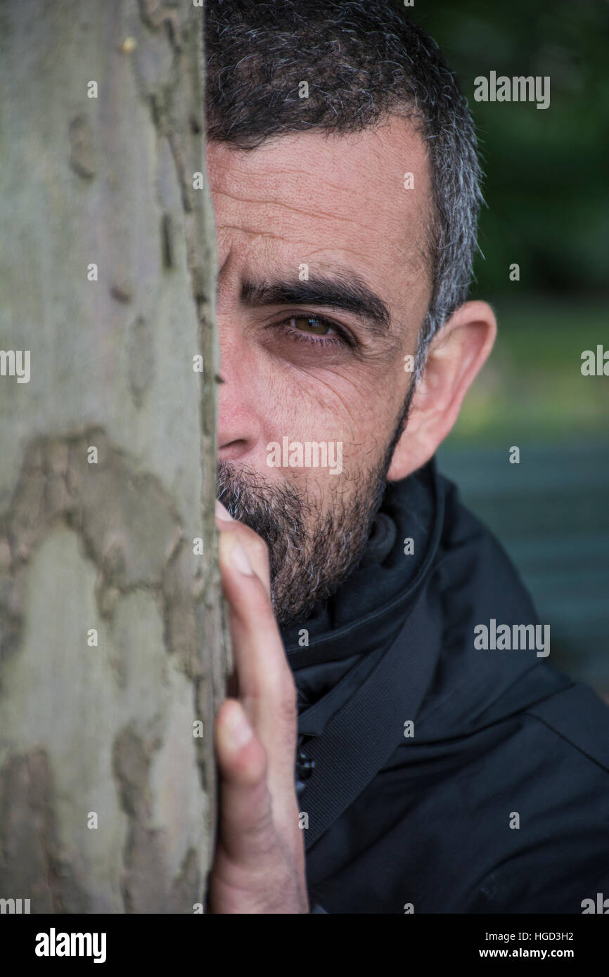 Dark man behind tree hi-res stock photography and images - Alamy