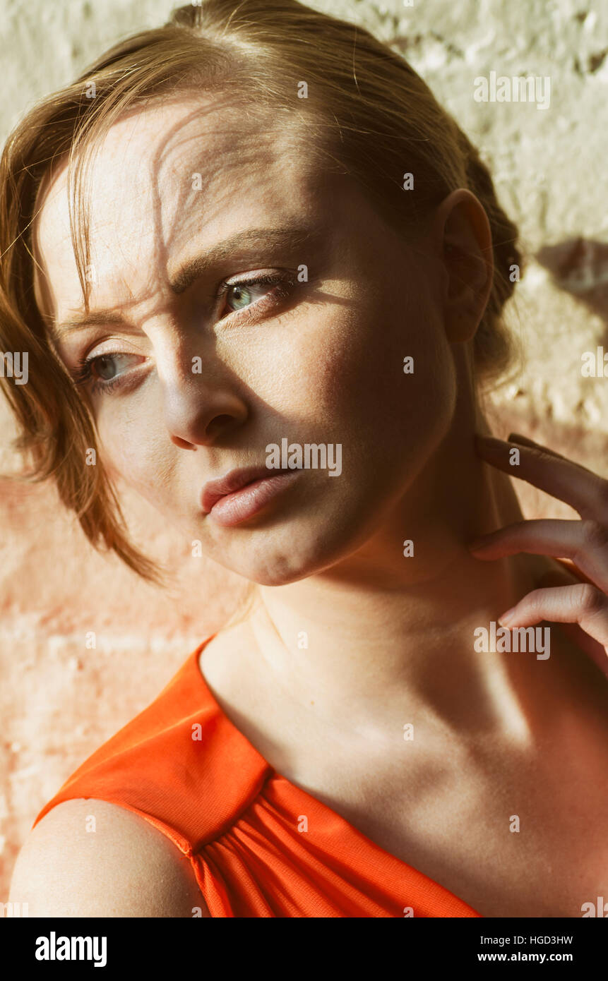 Beautiful young woman hand touching neck looking away Stock Photo - Alamy