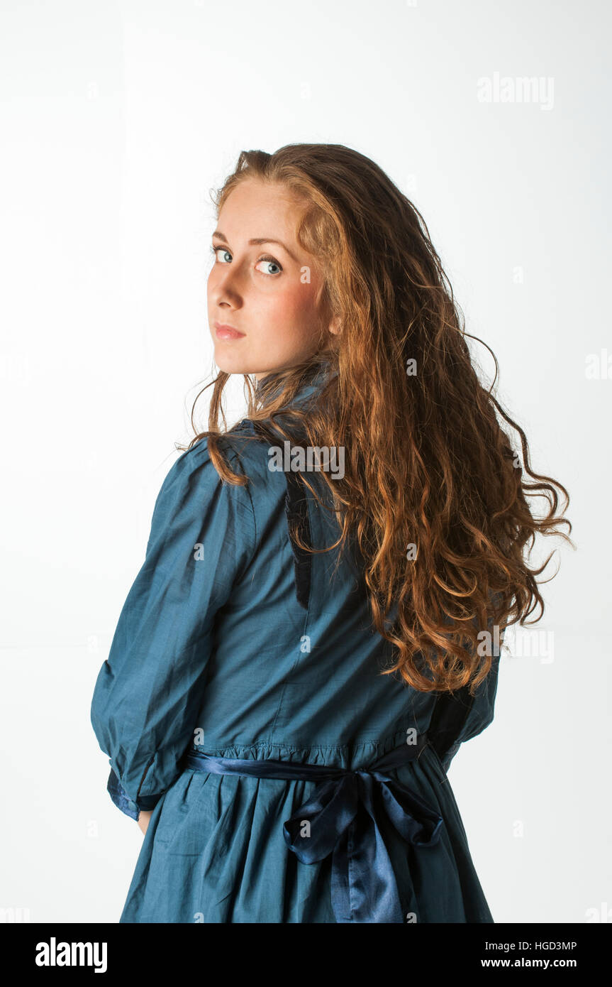 Beautiful young woman looking over shoulder against a white background ...