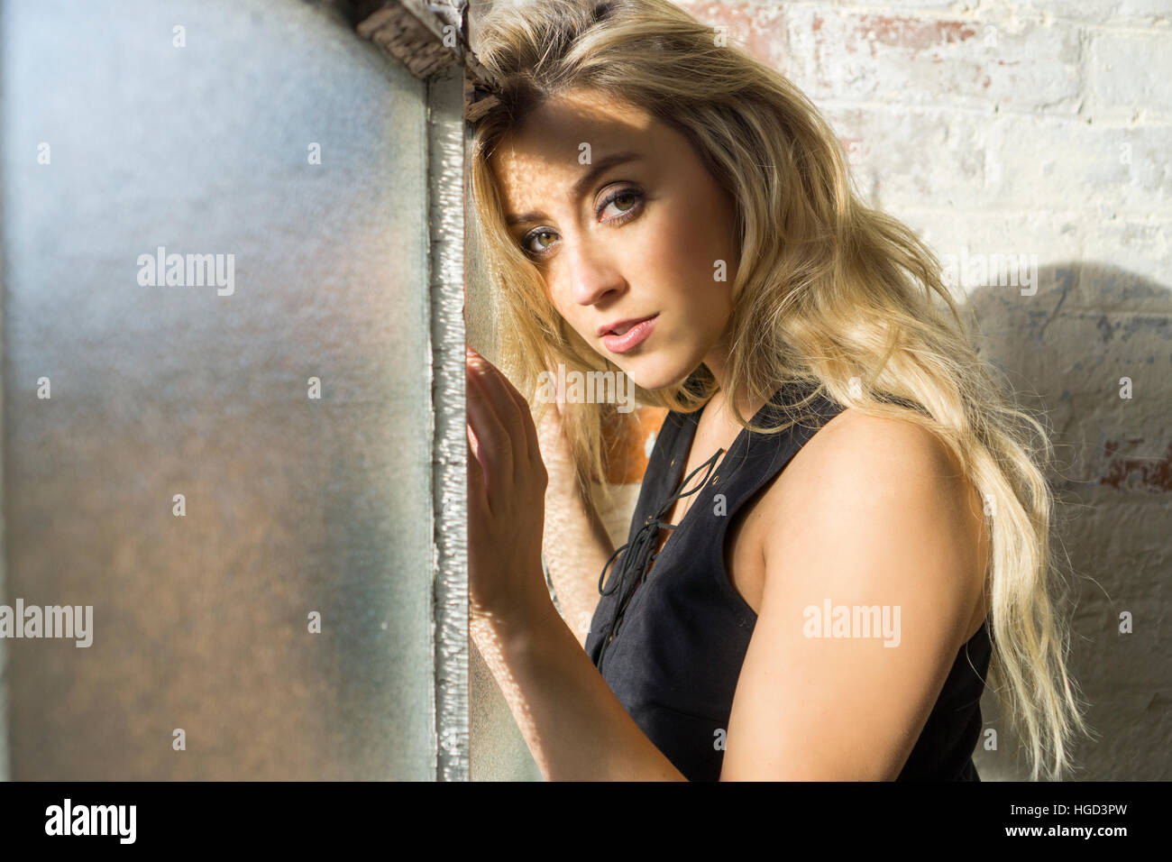 Beautiful blond woman standing by the window Stock Photo - Alamy