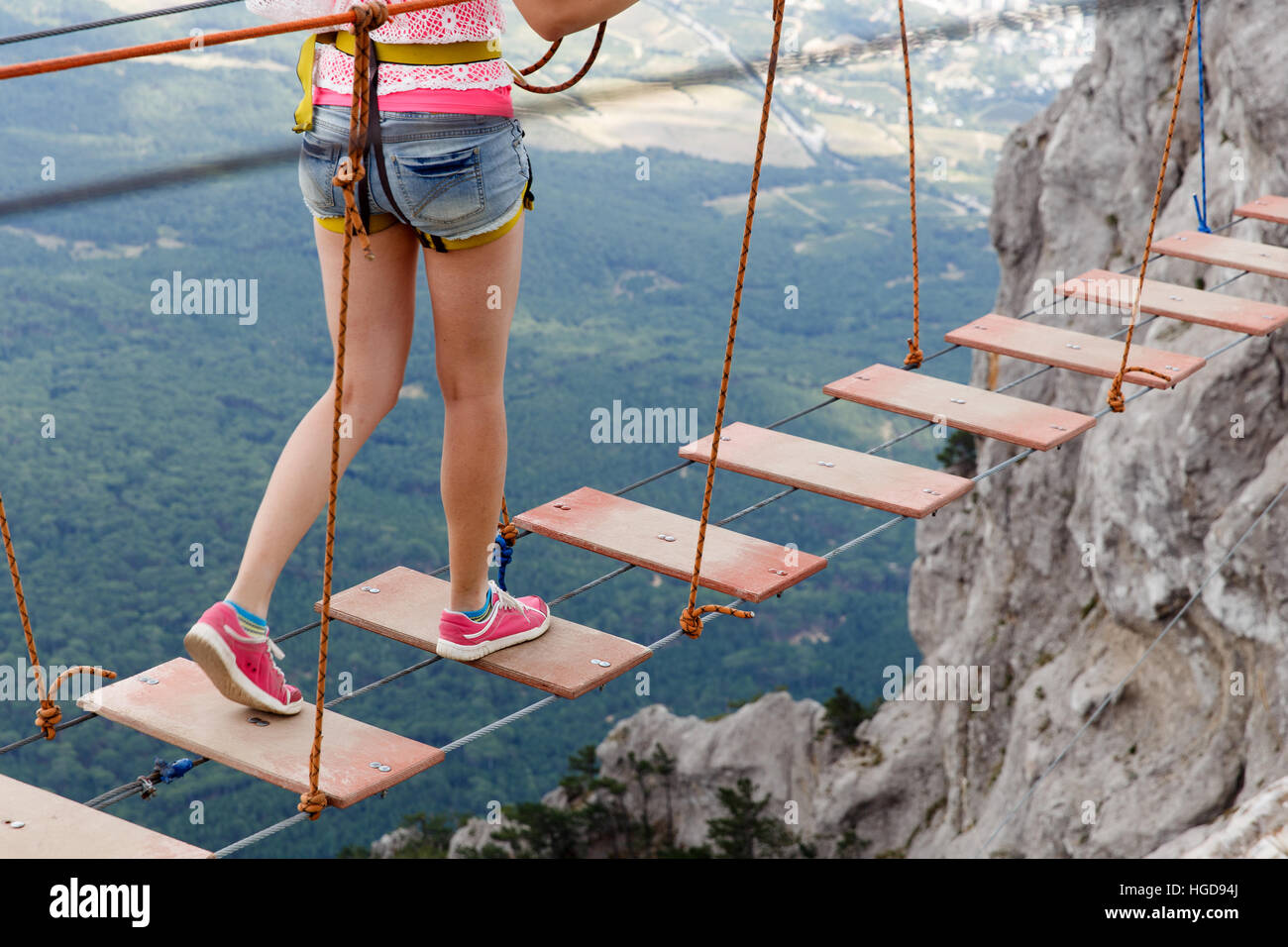 Young woman walking on ladder Stock Photo - Alamy