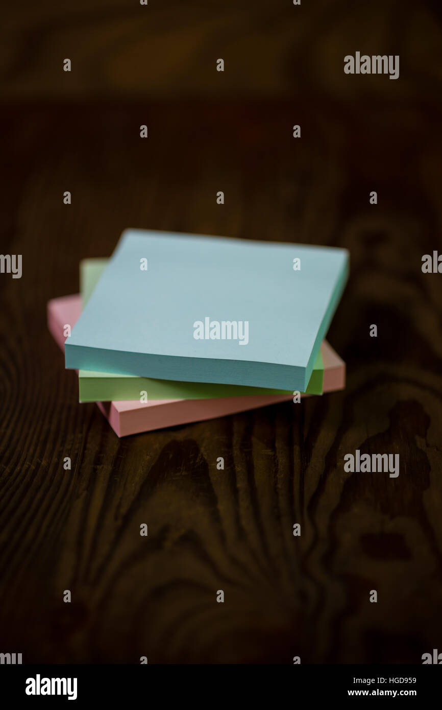 Stack of different colored notepads on ditressed wood background ...