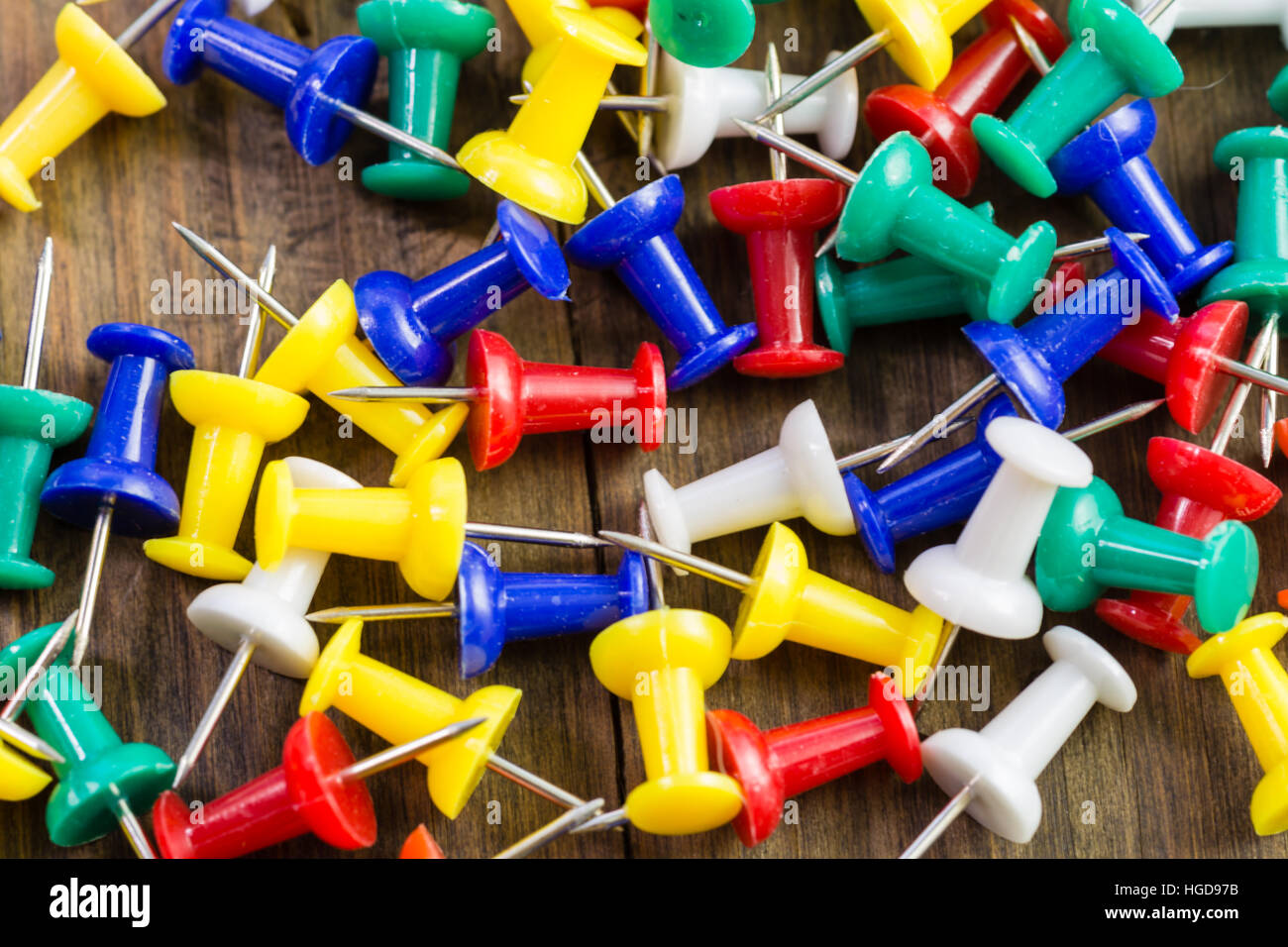 Pile of various color thumbtacks on distressed wood Stock Photo - Alamy