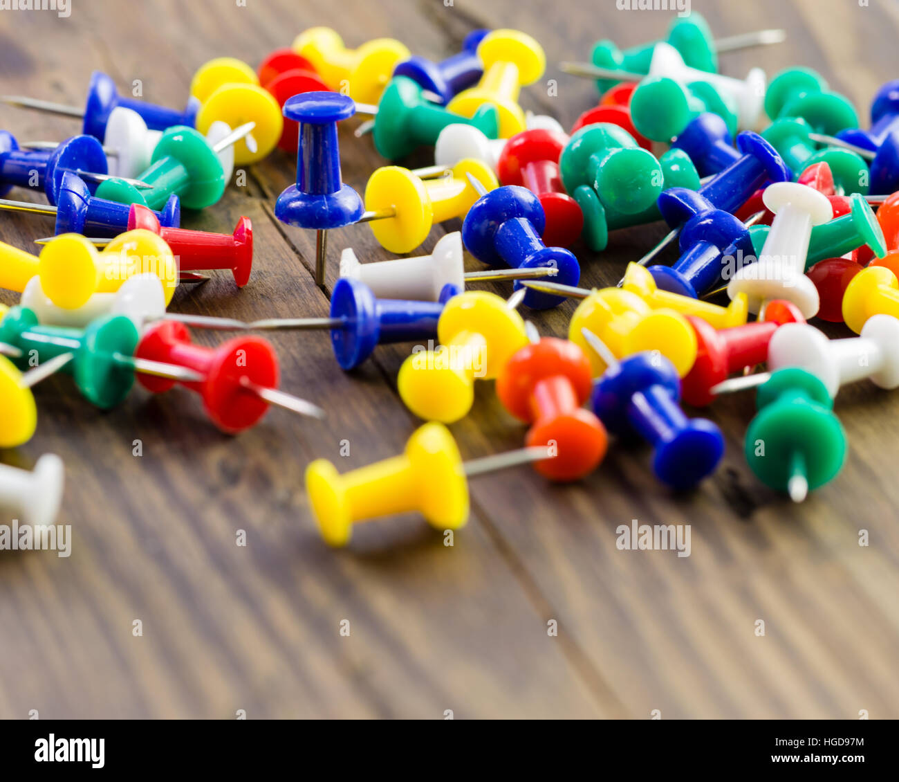 Pile of various color thumbtacks on distressed wood Stock Photo - Alamy