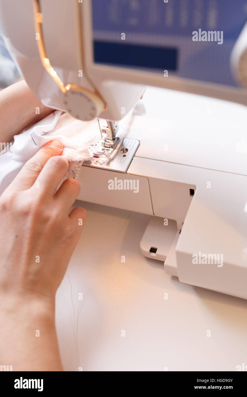 Seamstress sewing white cloth close-up Stock Photo - Alamy