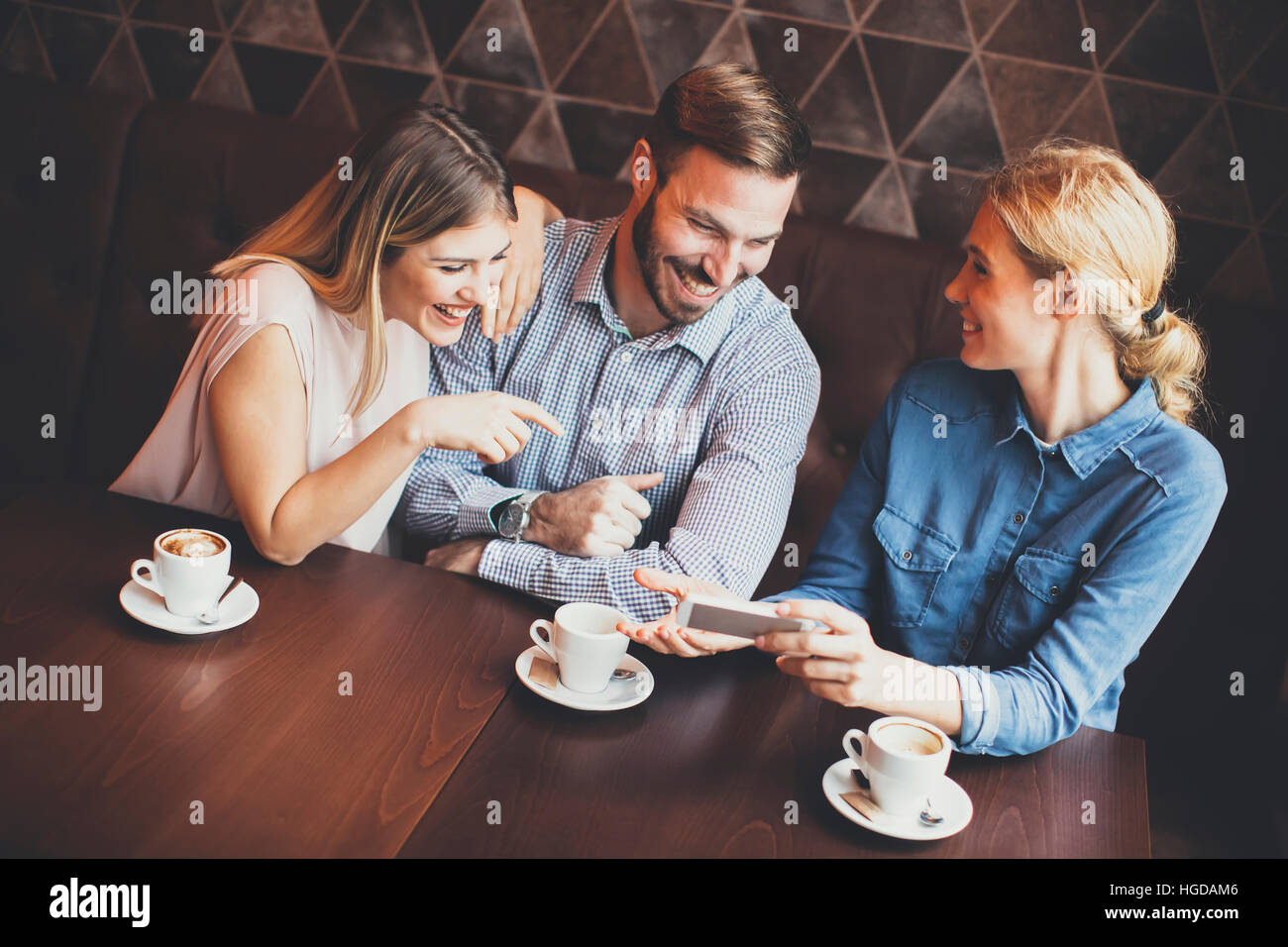 Young people sitting in cafe, drinking coffee and having fun Stock ...