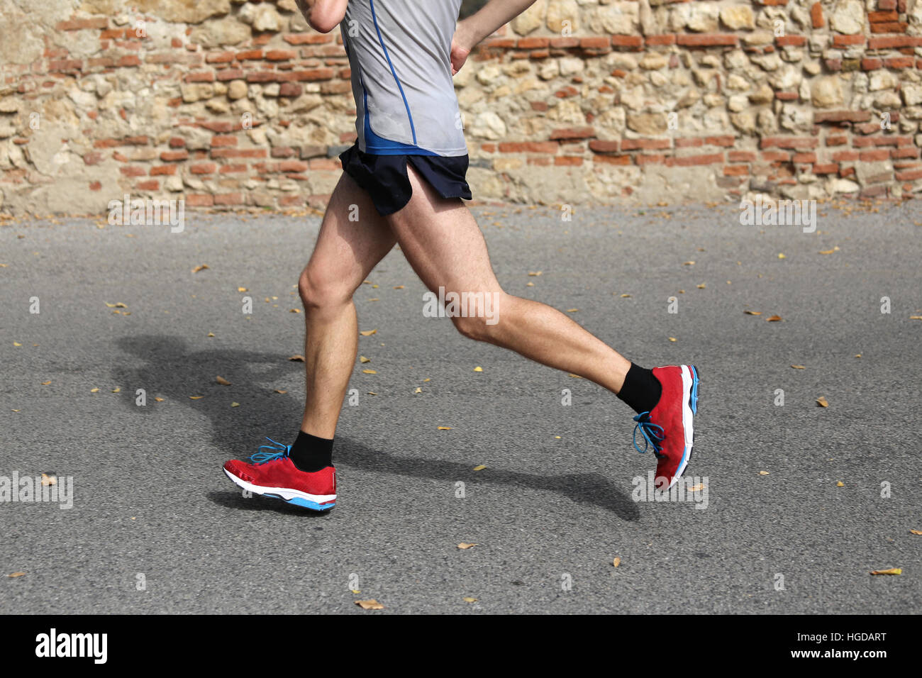fast runner running fast with by red gym shoes on the asphalt road in ...