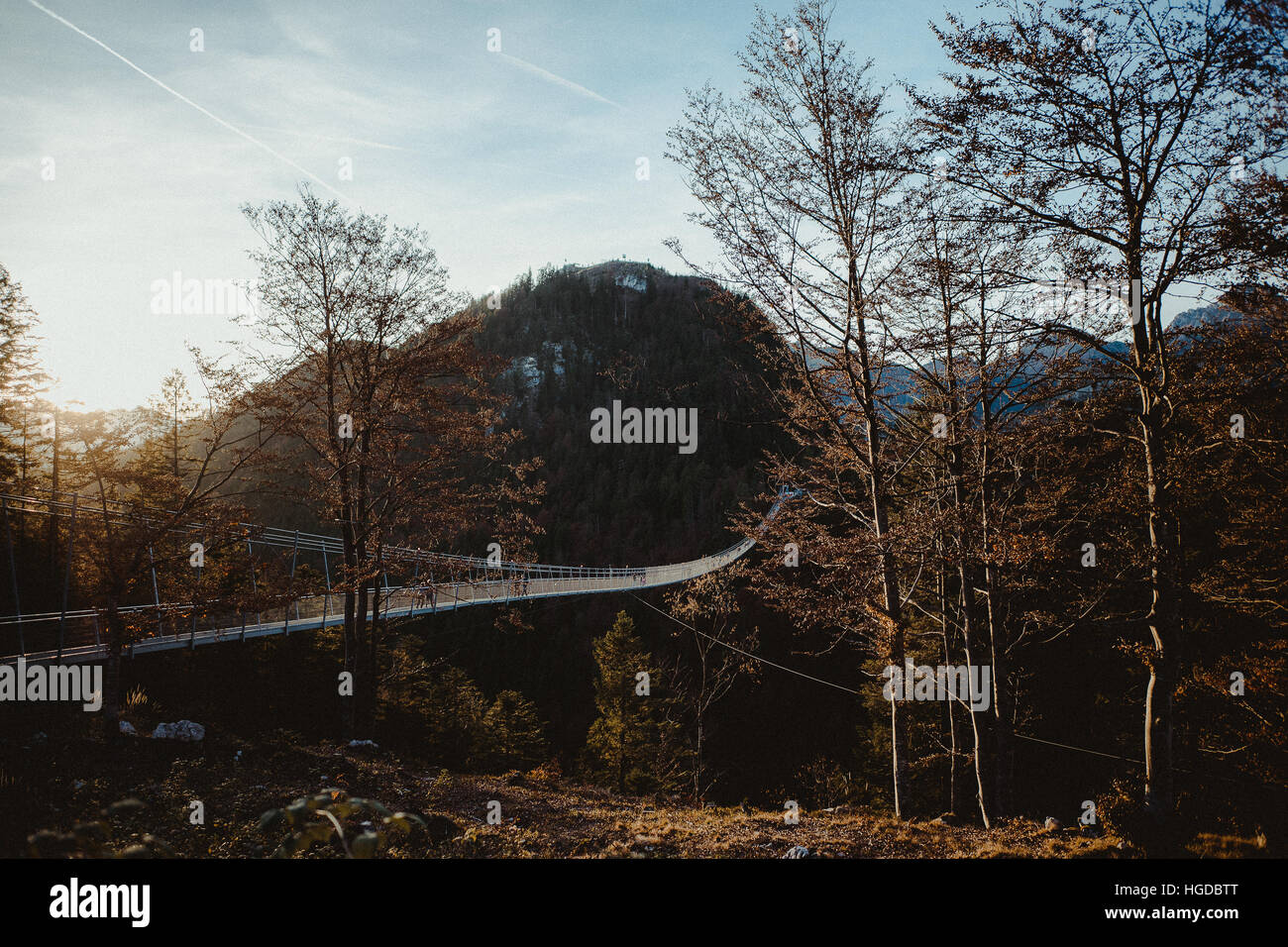 A Suspension bridge between two mountains at sunset Stock Photo - Alamy