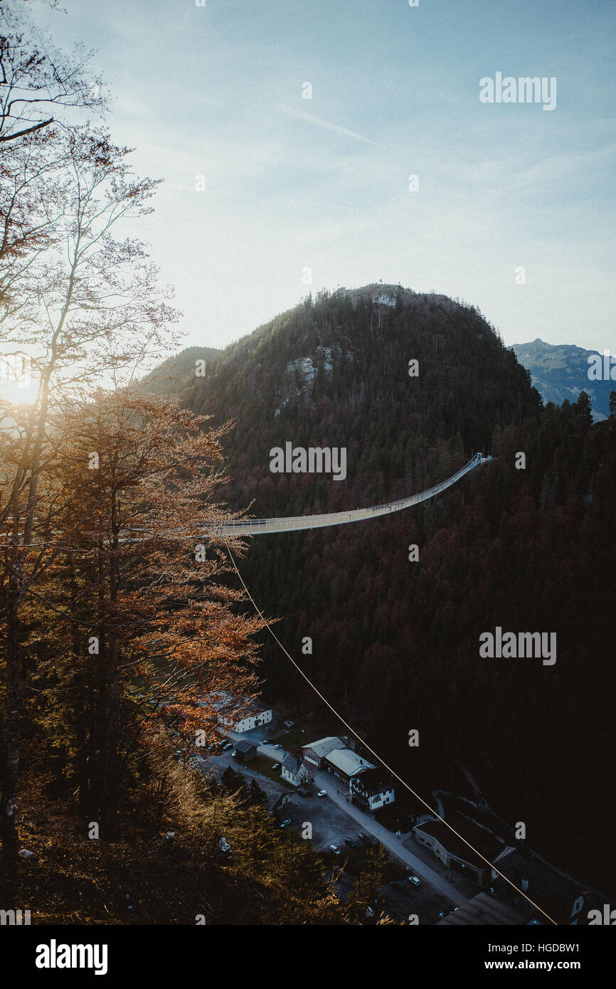 A Suspension bridge between two mountains at sunset Stock Photo - Alamy
