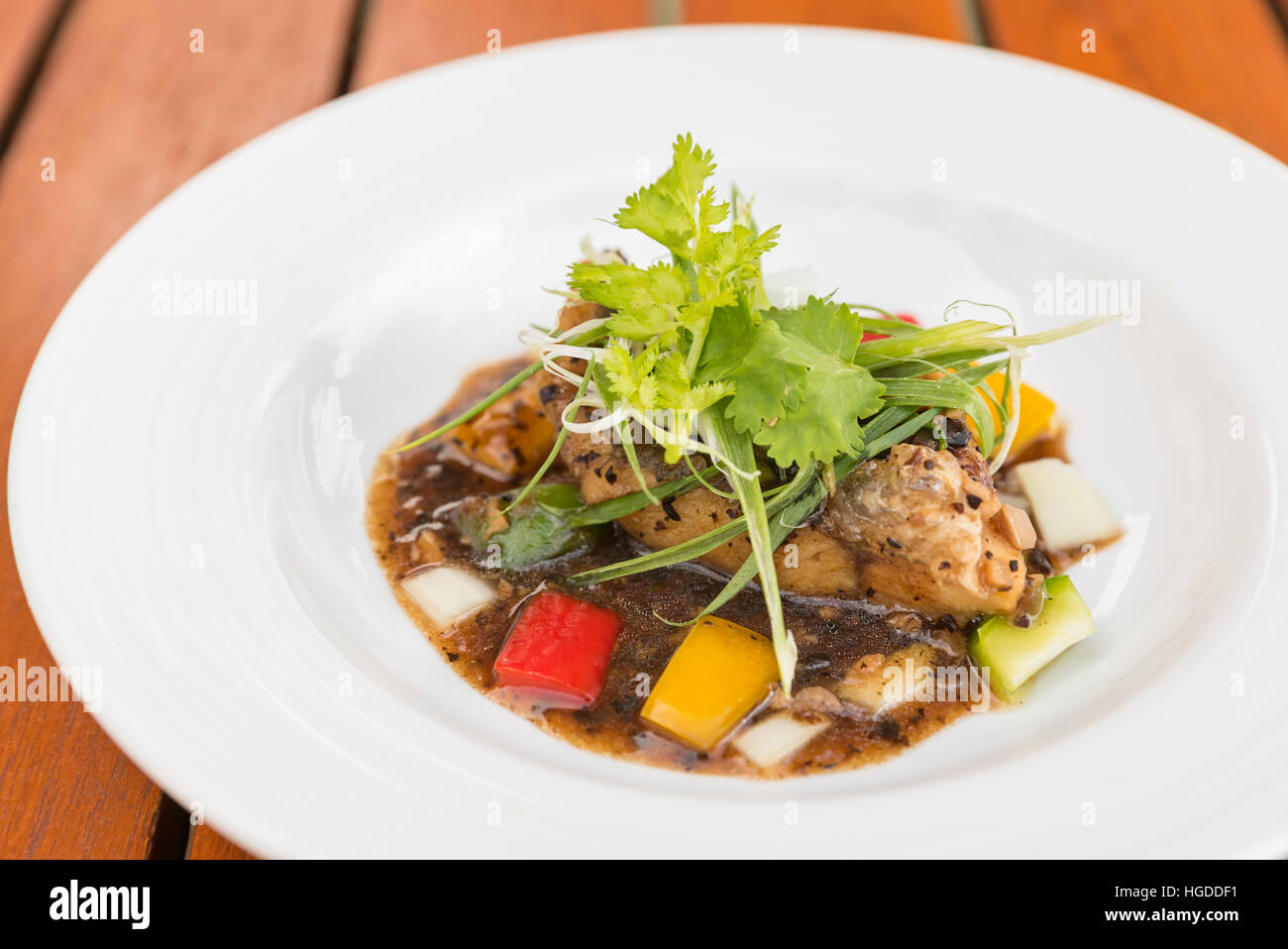 fried sea bass fillet with black pepper sauce Stock Photo - Alamy