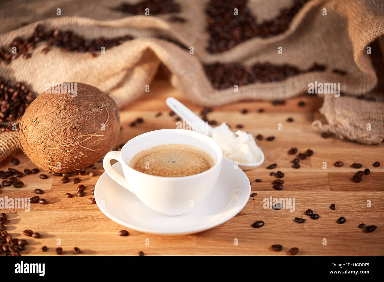 Bulletproof coffee with coconut butter on white spoon on brown table ...