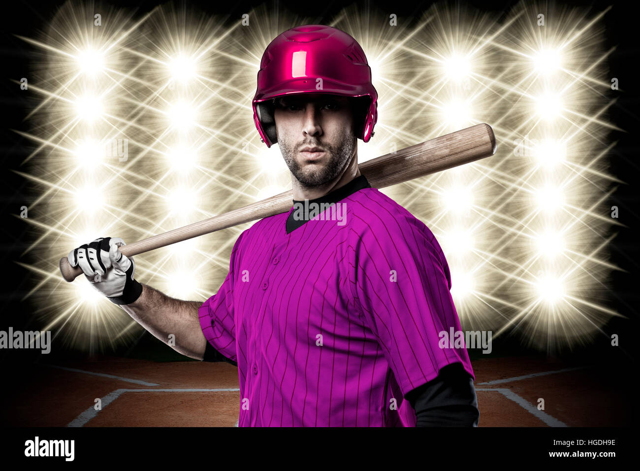 Baseball Player with a pink uniform in front of lights Stock Photo - Alamy