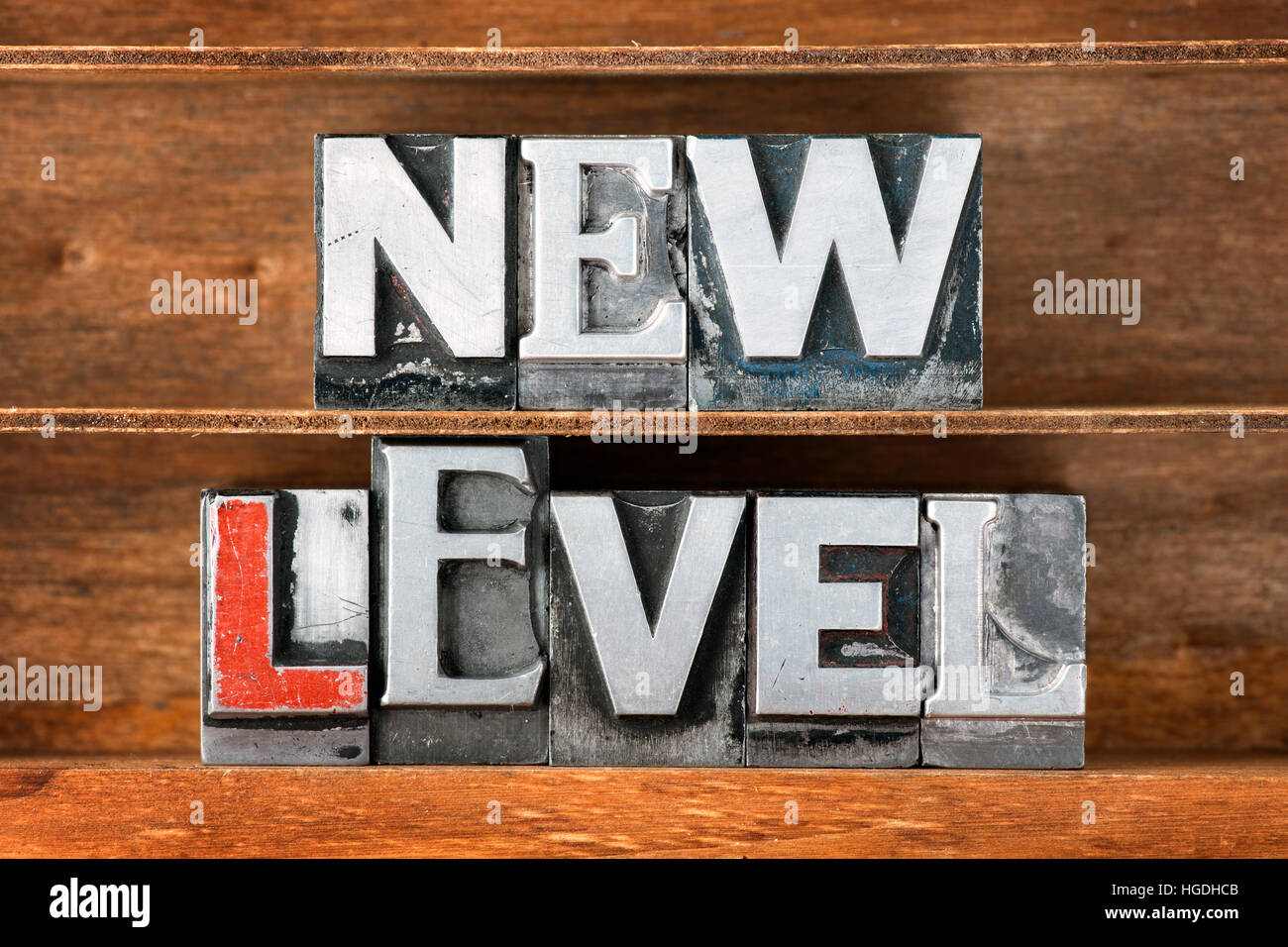 new level phrase made from metallic letterpress type on wooden tray ...