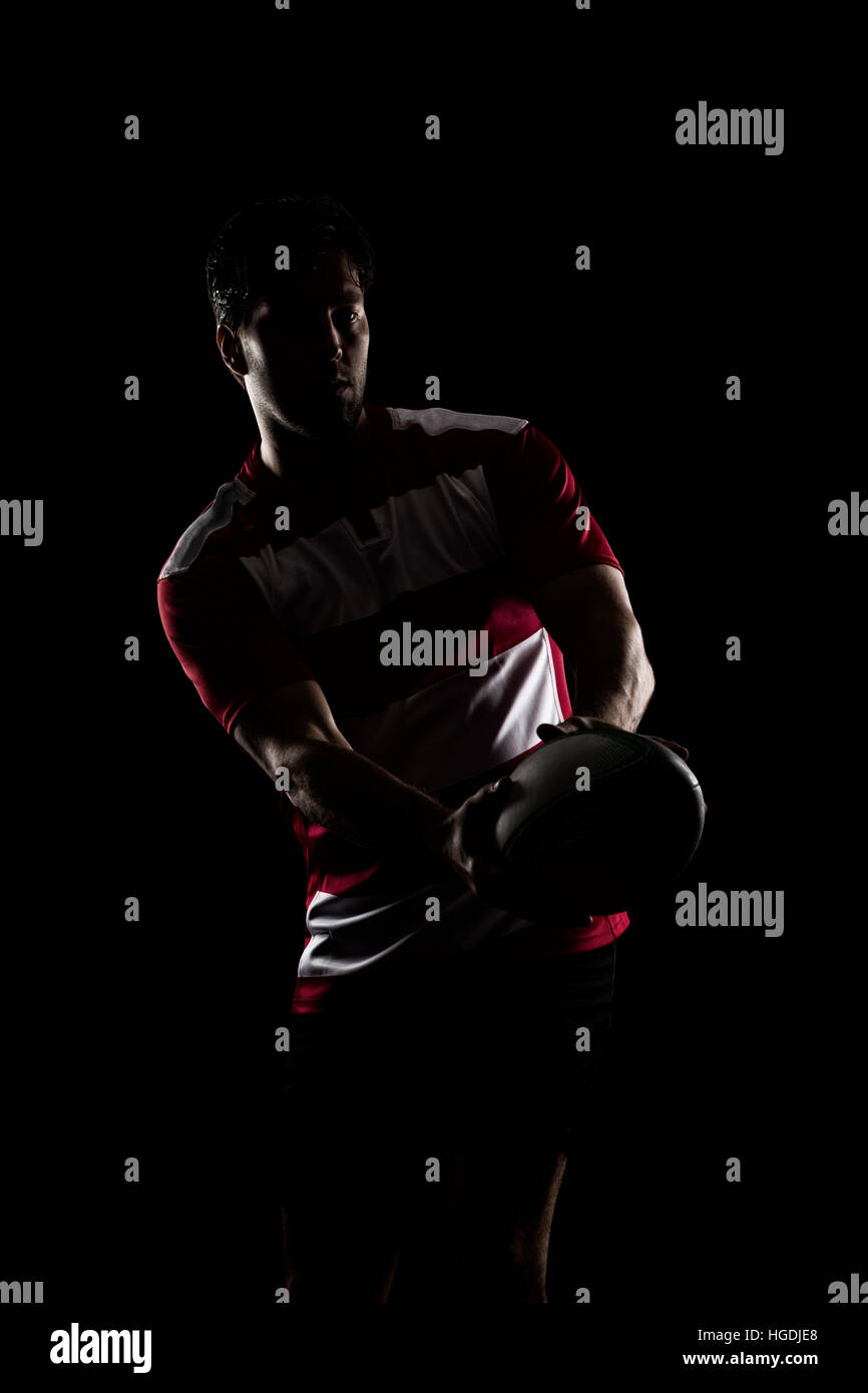 Rugby player in a red uniform. Black Background Stock Photo - Alamy