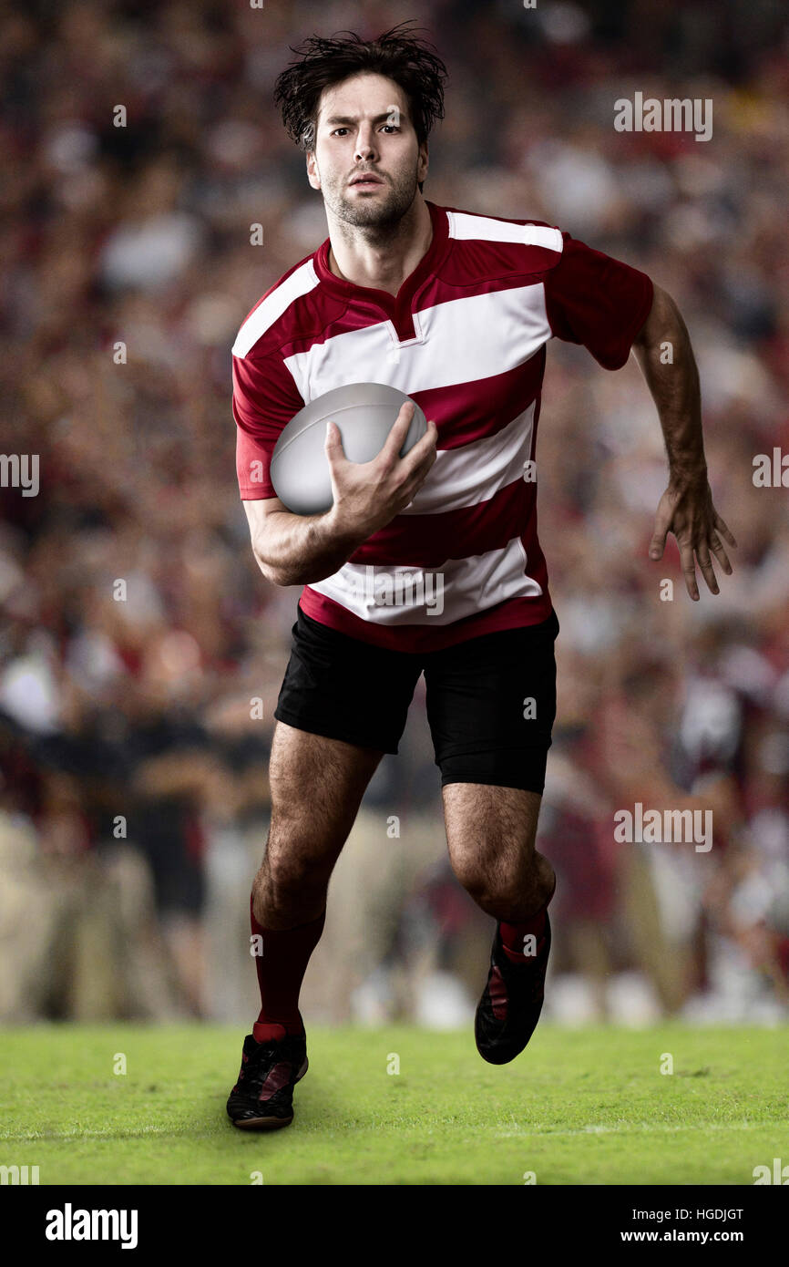 Rugby player in a red uniform running. White Background Stock Photo - Alamy