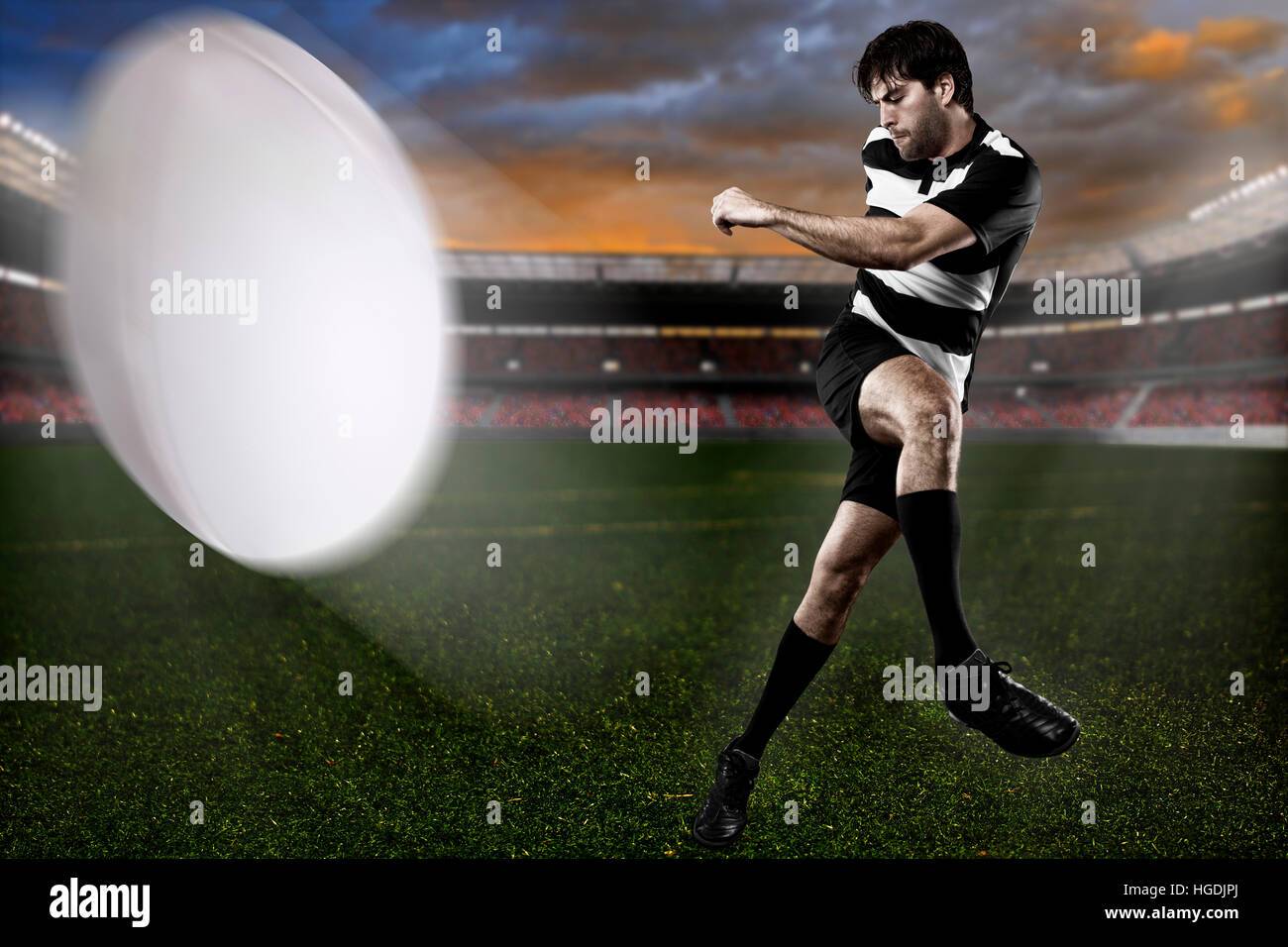 Rugby player in a black and white uniform kicking on a stadium Stock ...