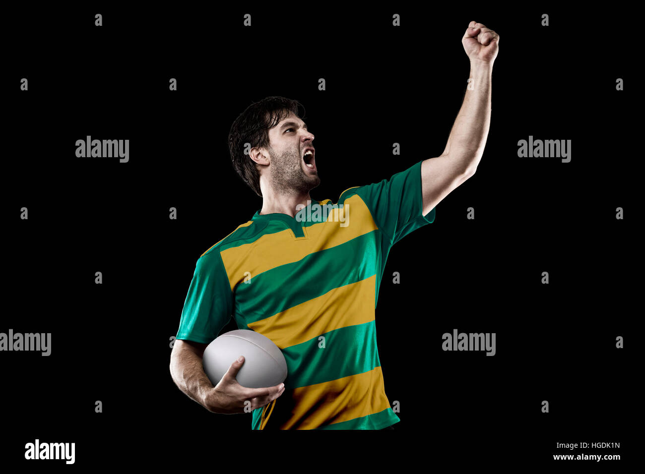 Rugby player in a green and gold uniform celebrating. Black Background ...