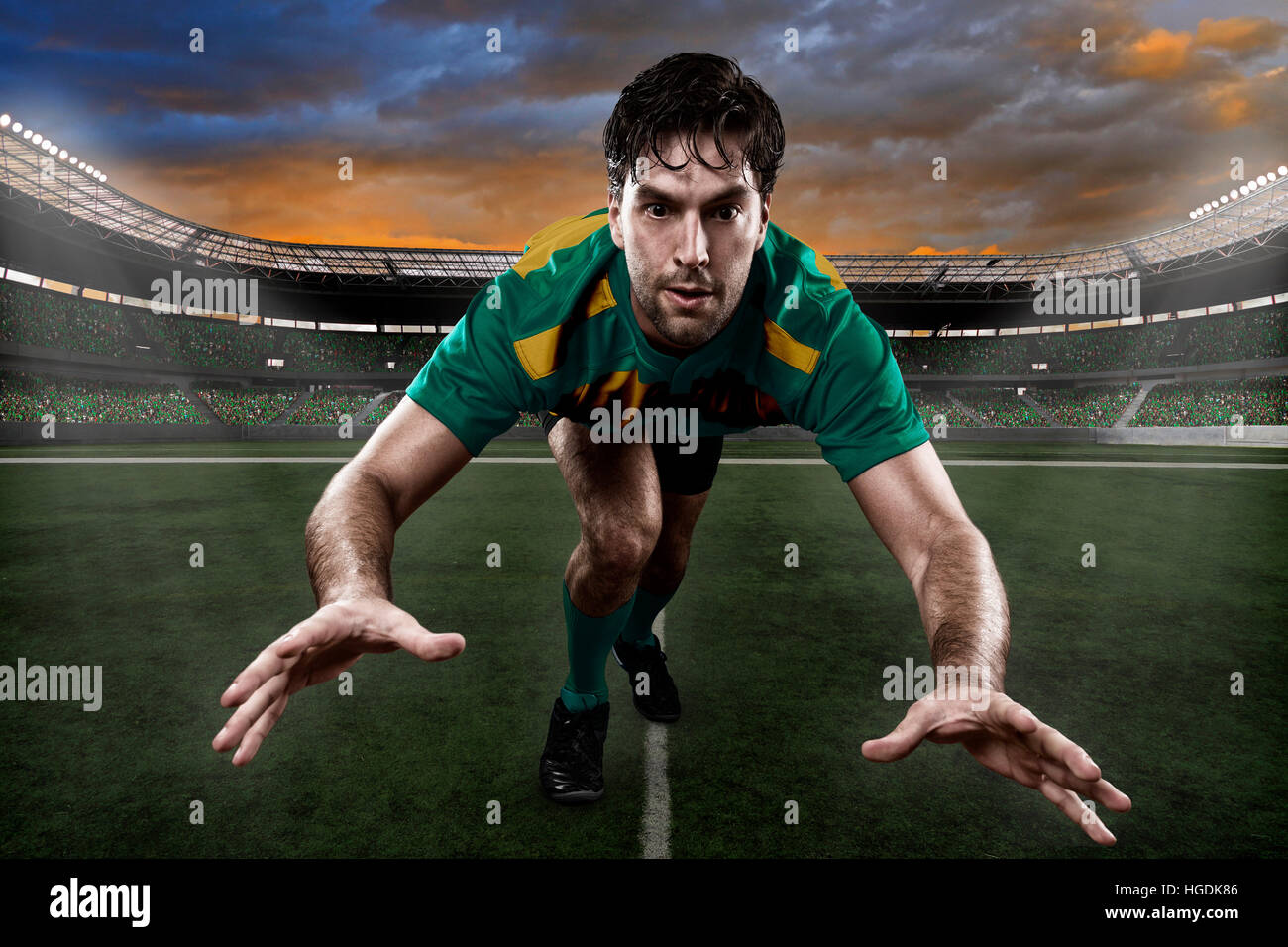 Rugby player in a green and gold uniform giving a tackle on a stadium ...