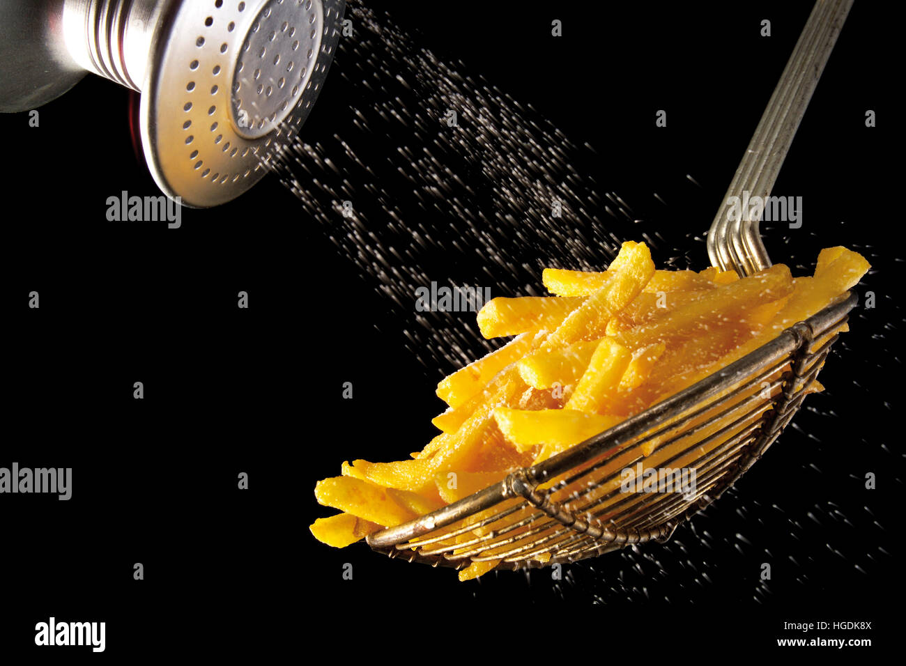 Adding salt to chips Stock Photo - Alamy