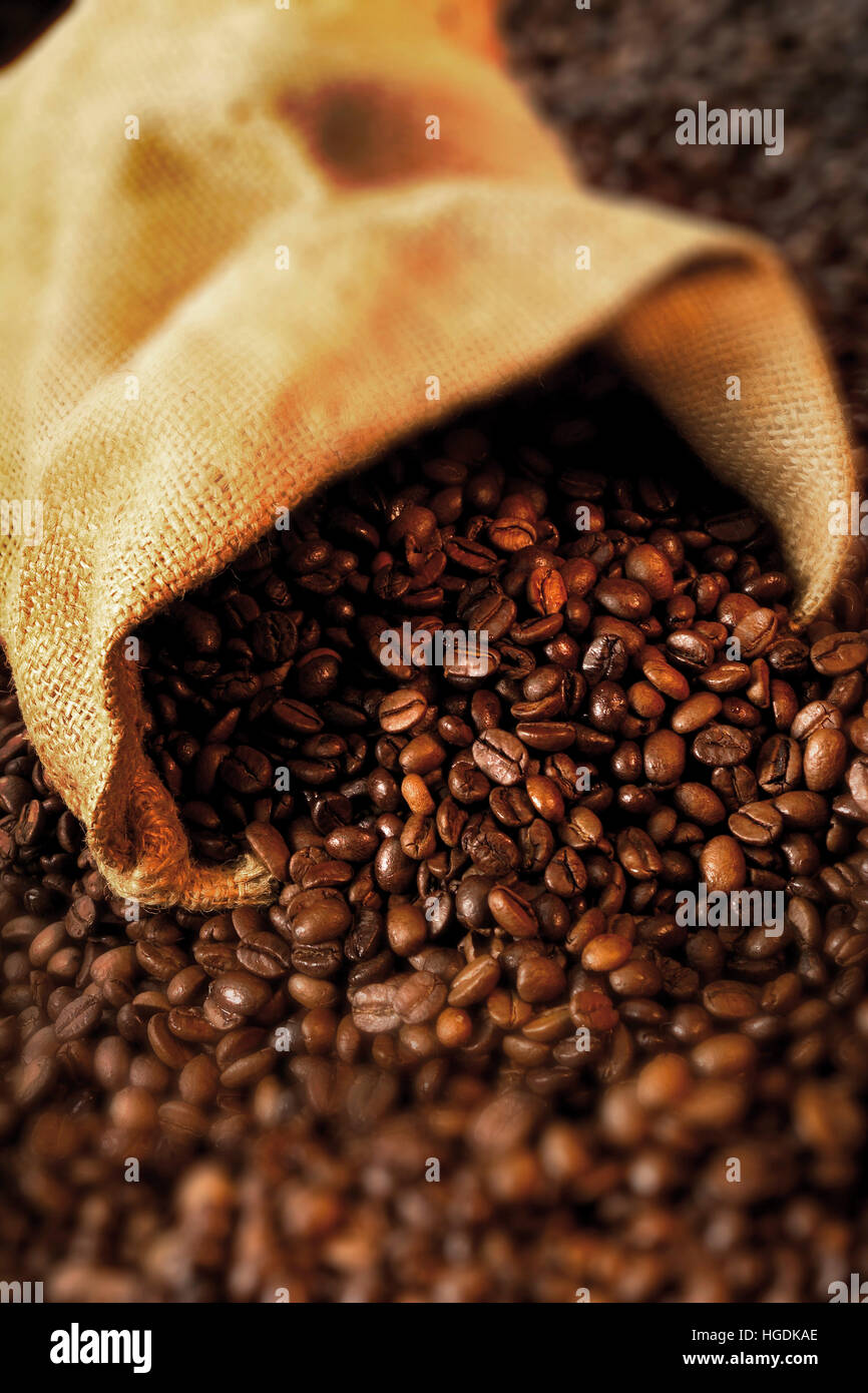 Bed of coffee beans spilling out of a linen sack Stock Photo - Alamy