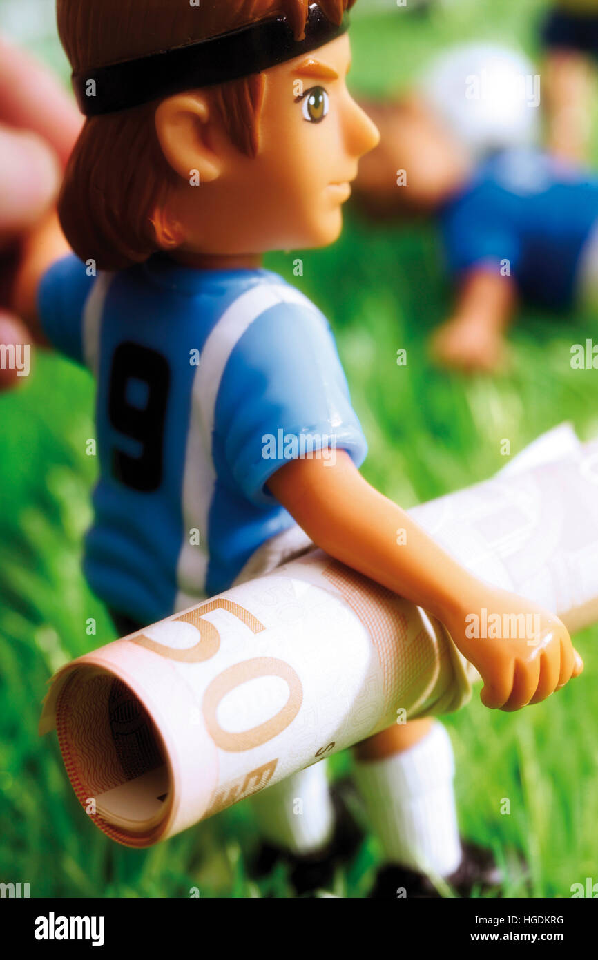 Football player holding money: symbol for corruption Stock Photo - Alamy