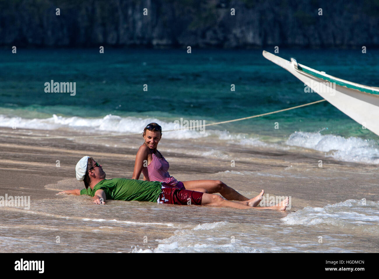Couple relax on remote beach Bacuit Archipelago Palawan Philippines ...