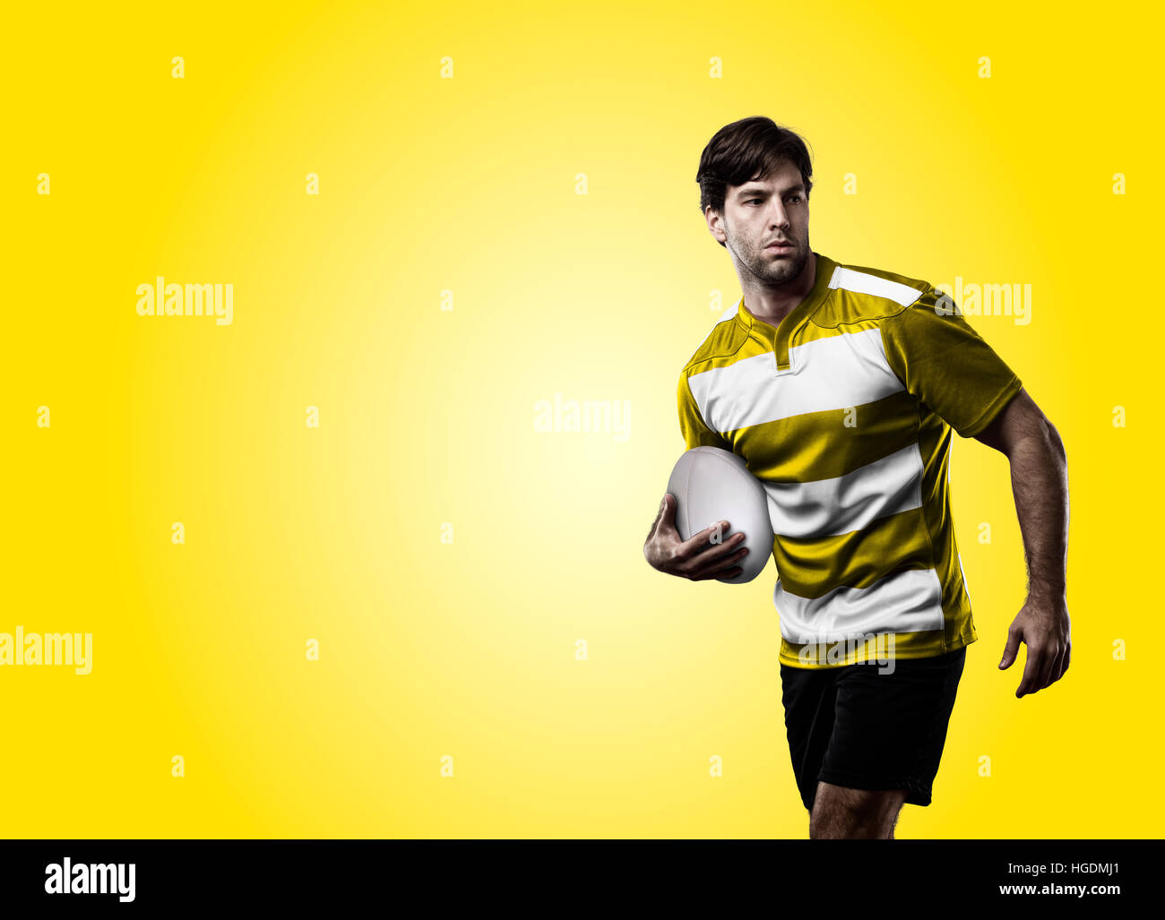 Rugby player in a yellow uniform on a yellow background Stock Photo - Alamy