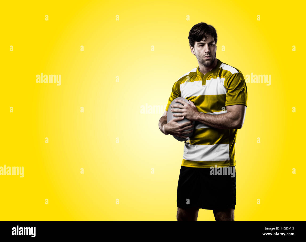Rugby player in a yellow uniform on a yellow background Stock Photo - Alamy