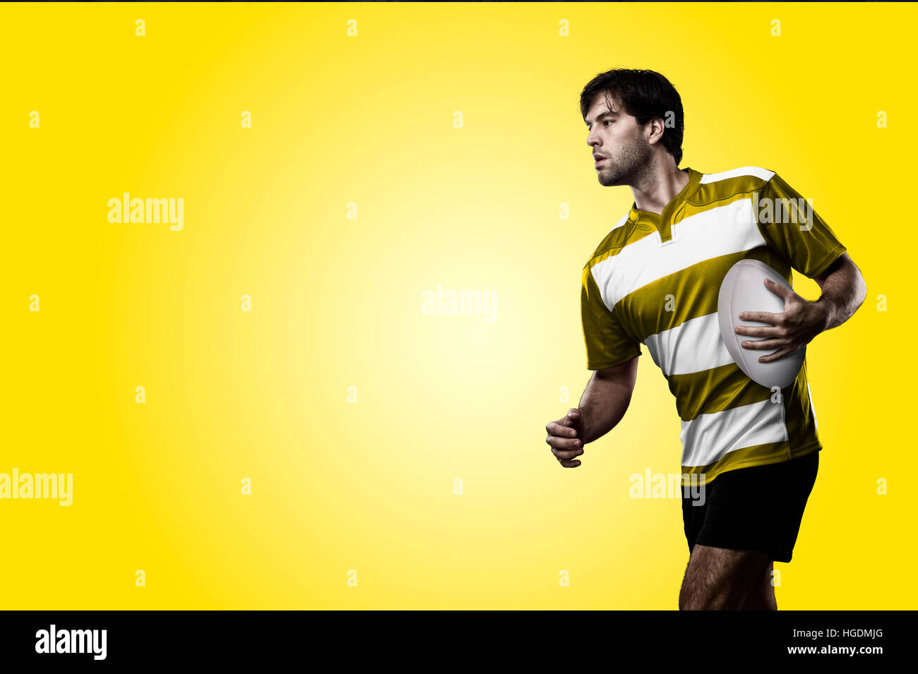 Rugby player in a yellow uniform on a yellow background Stock Photo - Alamy