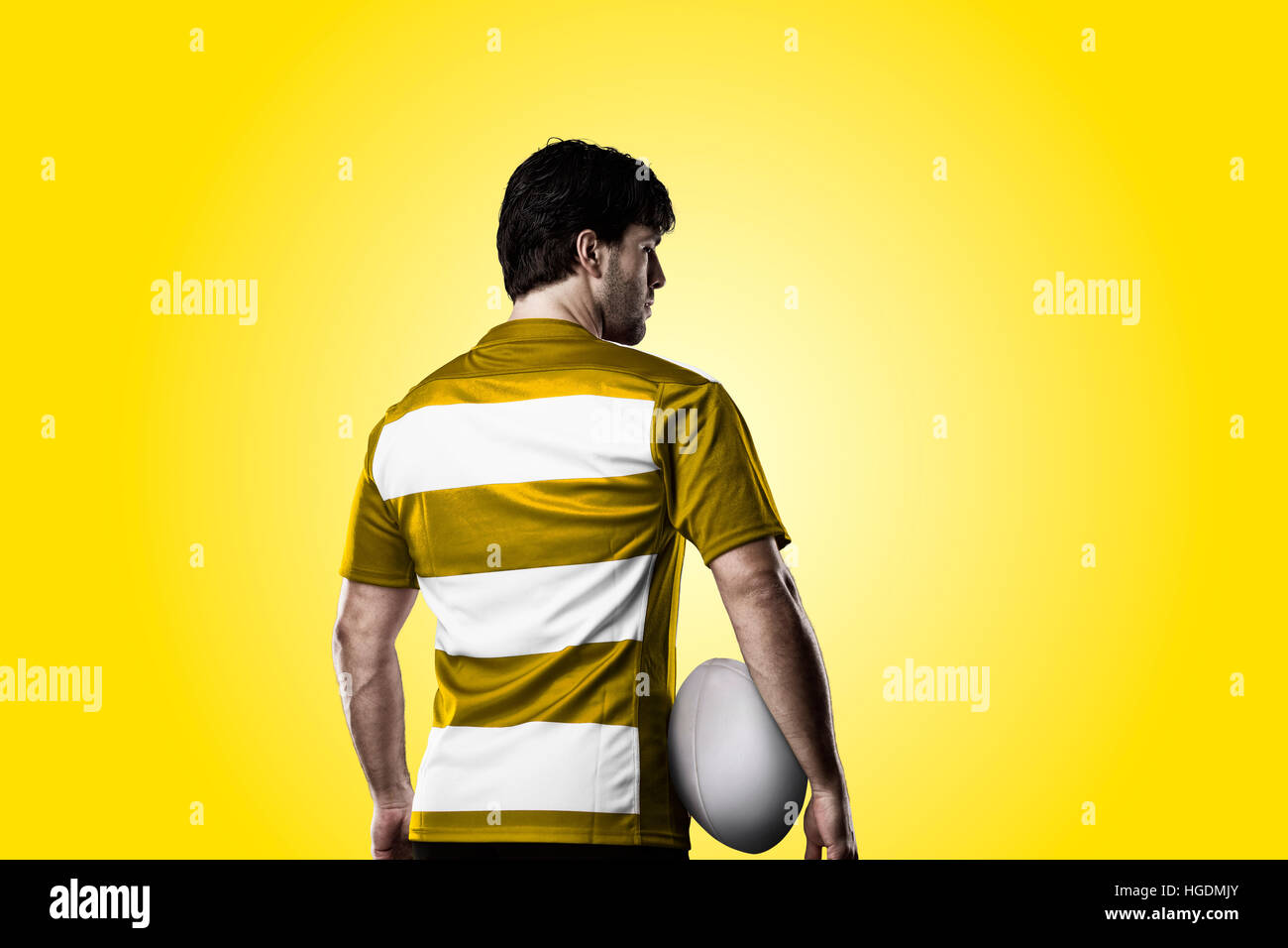 Rugby player in a yellow uniform on a yellow background Stock Photo - Alamy