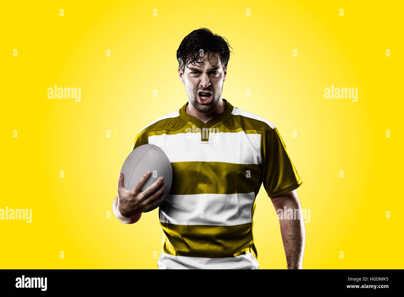 Rugby player in a yellow uniform on a yellow background Stock Photo - Alamy