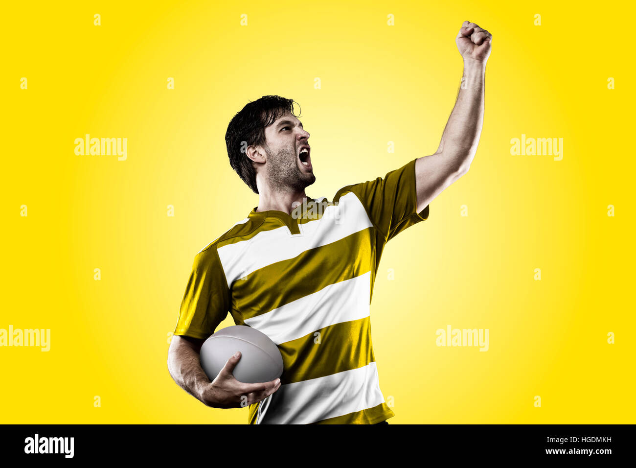 Rugby player in a yellow uniform celebrating on a yellow background ...
