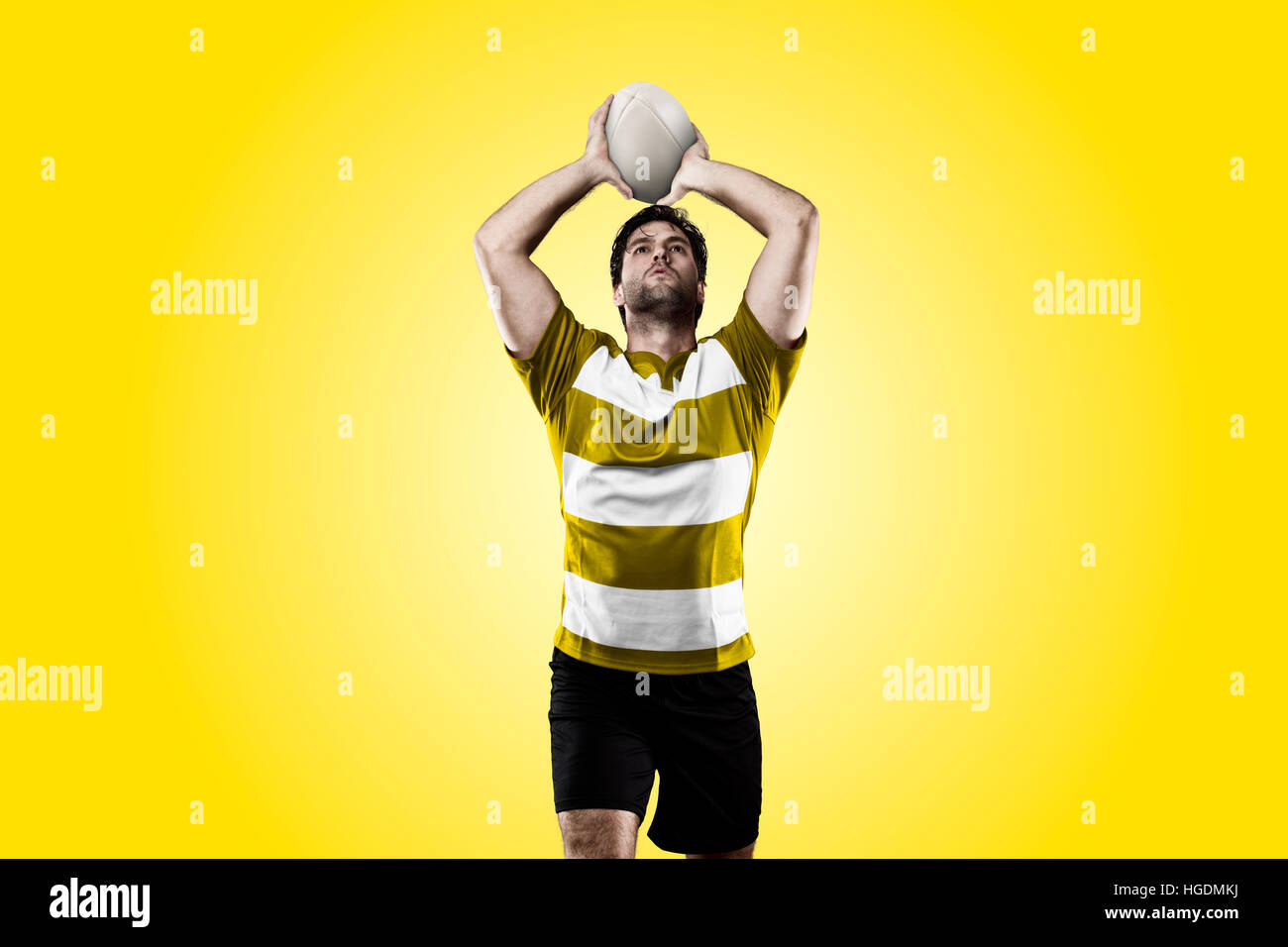 Rugby player in a yellow uniform on a yellow background Stock Photo - Alamy
