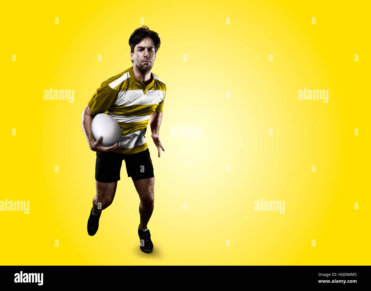 Rugby player in a yellow uniform running on a yellow background Stock ...