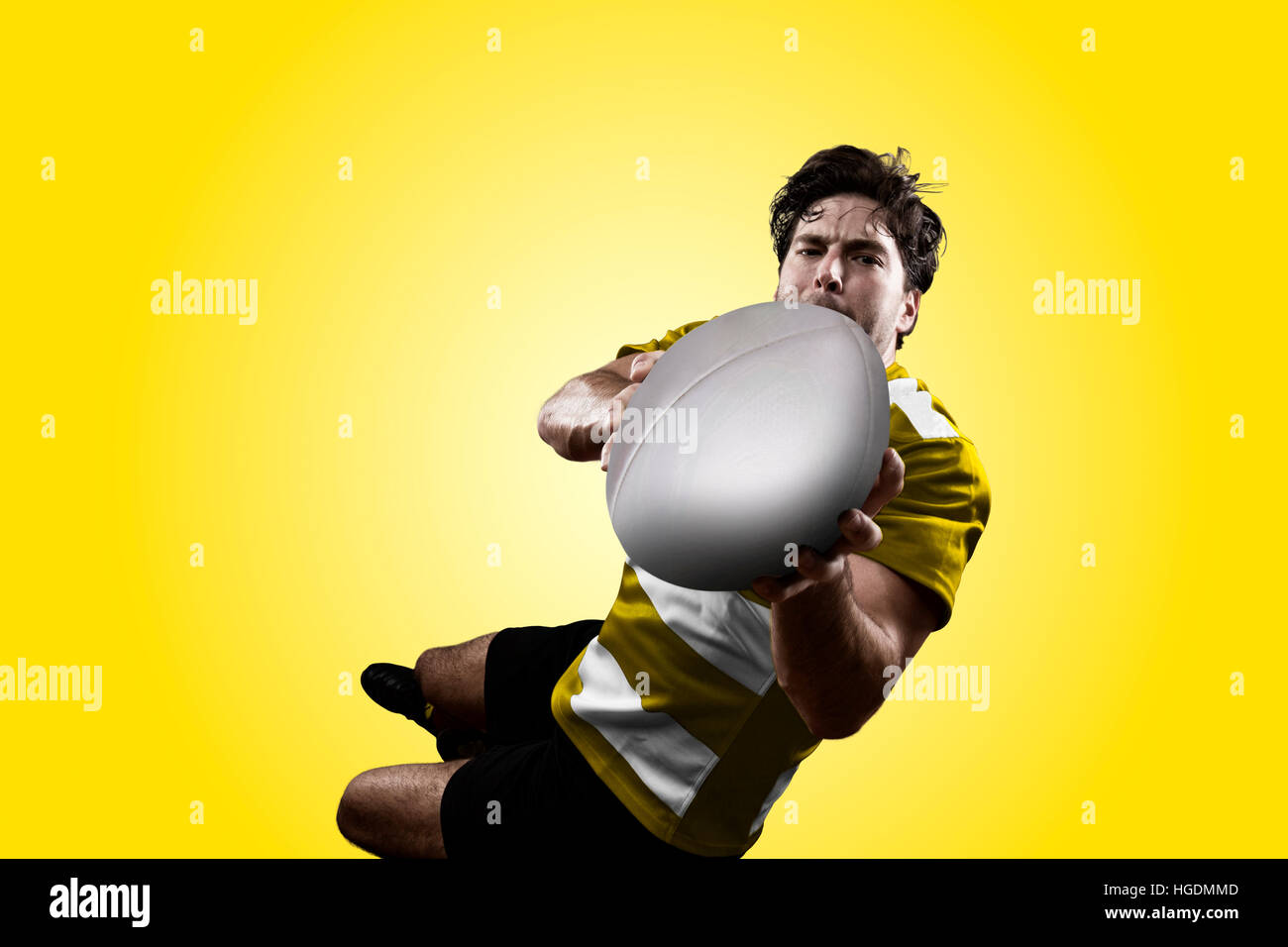 Rugby player in a yellow uniform scoring on a yellow background Stock ...