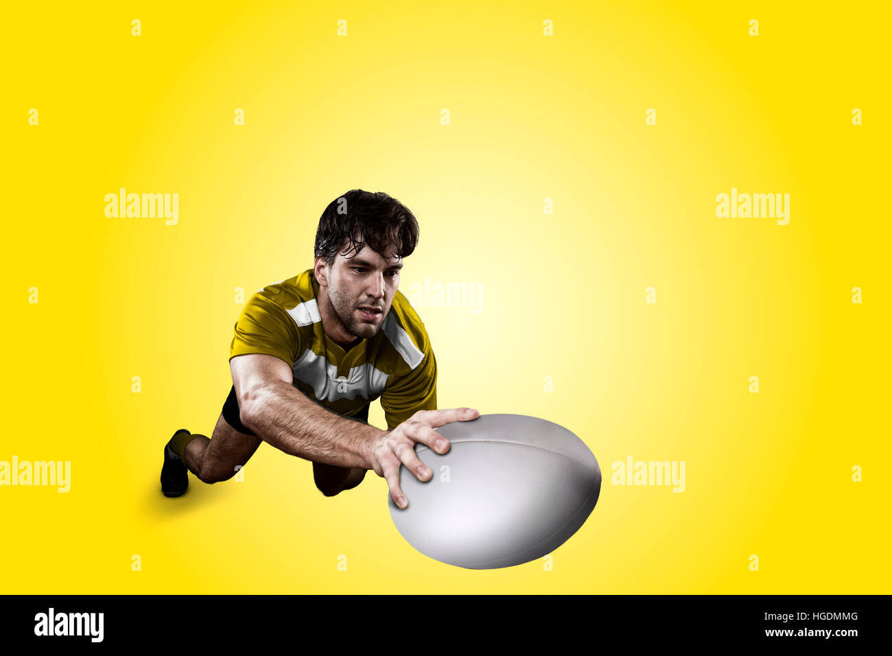 Rugby player in a yellow uniform scoring on a yellow background Stock ...