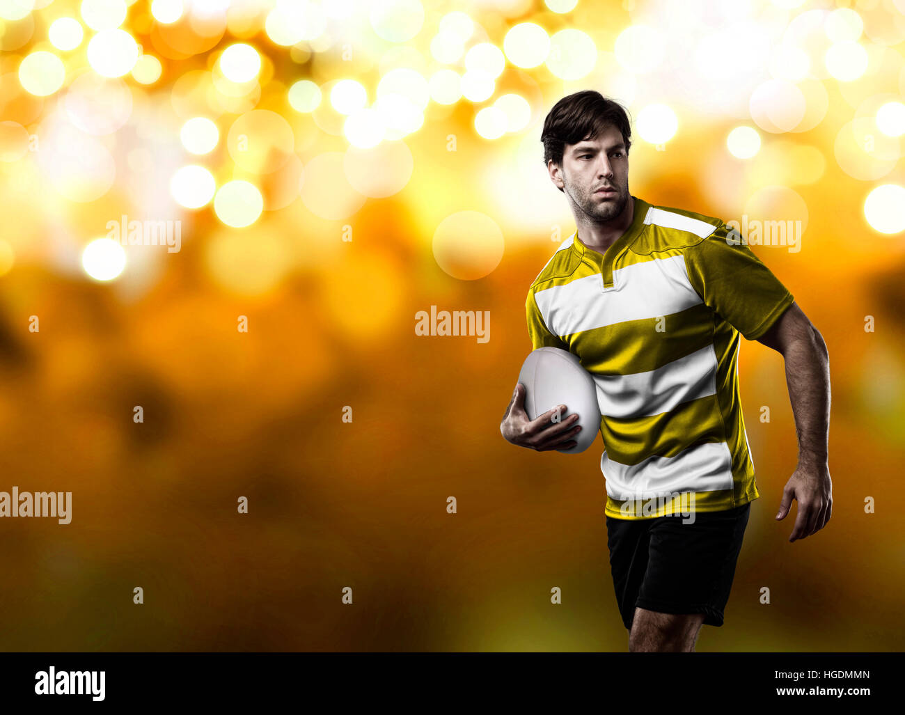 Rugby player in a yellow uniform on a yellow lights background Stock ...